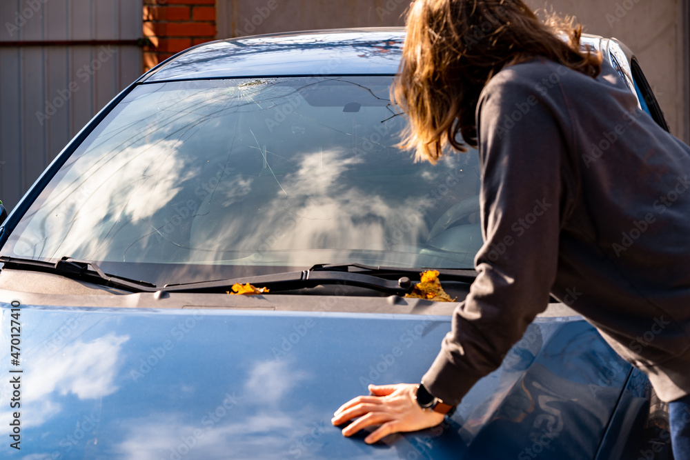 Shocked woman in car with broken windshield and cracks. Car accident ...