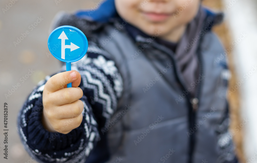 toy traffic signs in a kid boy hand. plastic road sign with speed limit ...