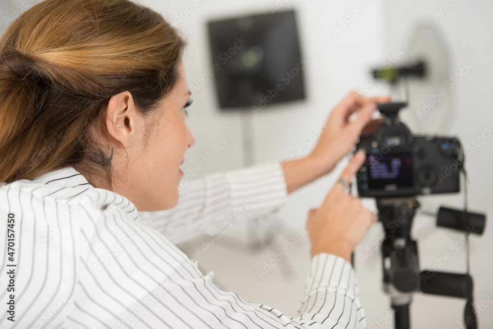 female photographer setting up camera in studio Stock Photo | Adobe Stock