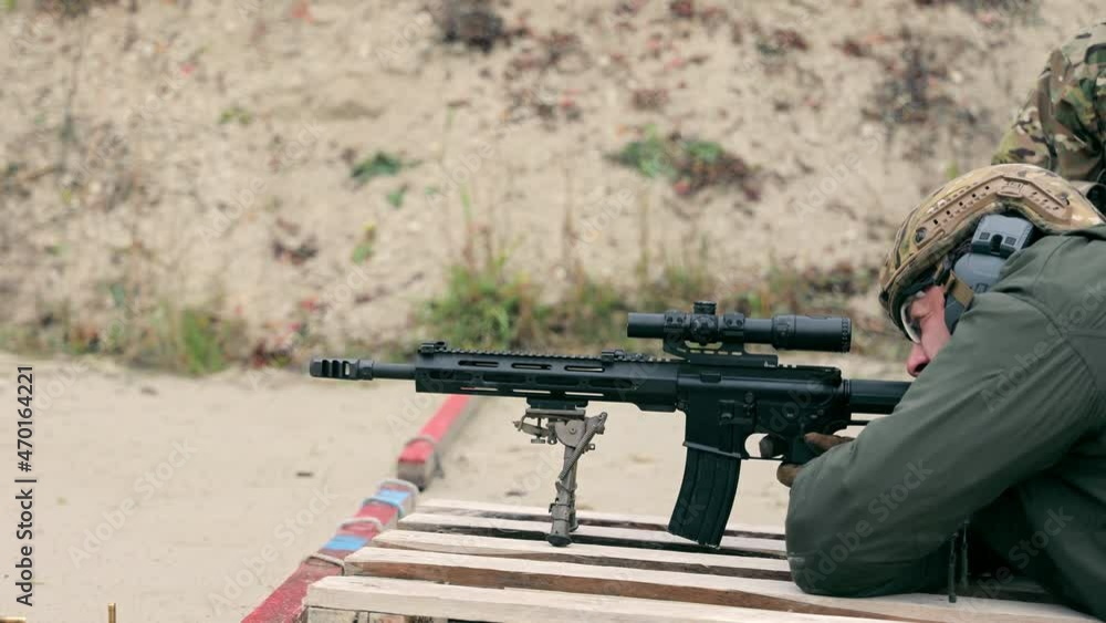 Shot of a sniper lying down holding a sniper rifle. Fighting and a ...