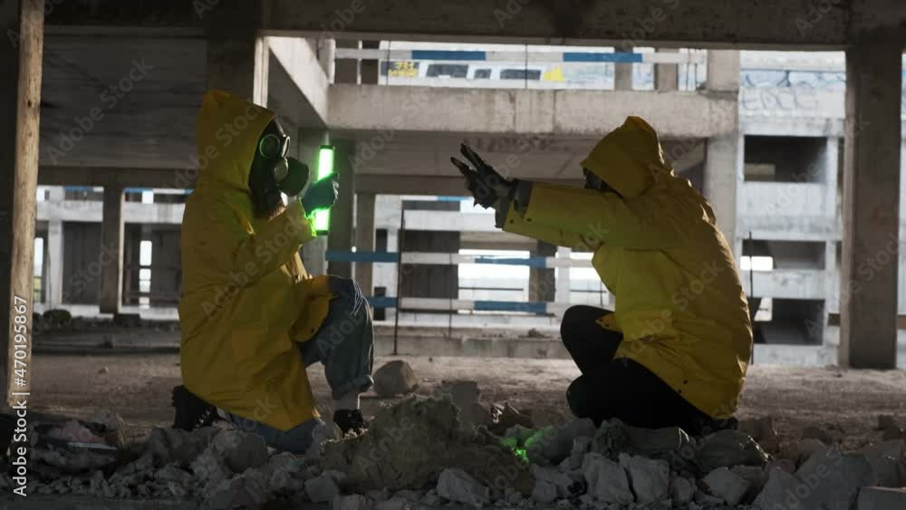 Two mad scientists in yellow overalls and gas masks find green tube ...