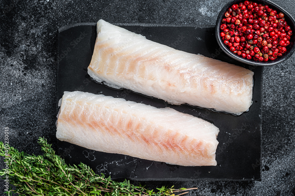 Raw cod loin fillet fish on marble board. Black background. Top view ...
