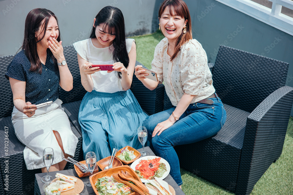 屋上でパーティーをする女性たち（スマホ） Stock Photo | Adobe Stock