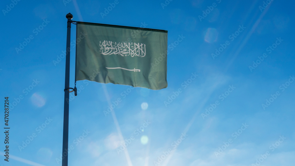Flag of Saudi Arabia against the blue sky with sun rays. Diplomacy ...