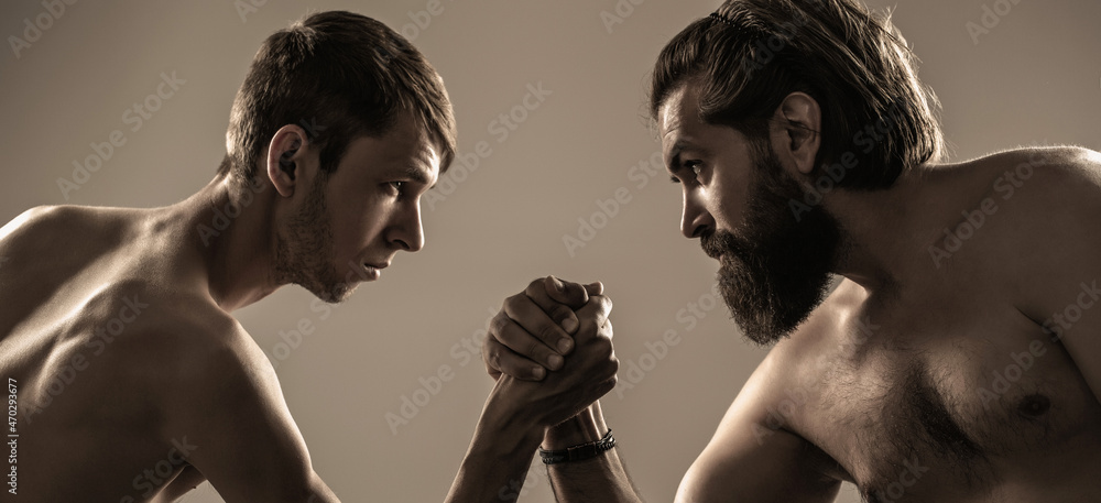 Heavily muscled bearded man arm wrestling a puny weak man. Arms ...