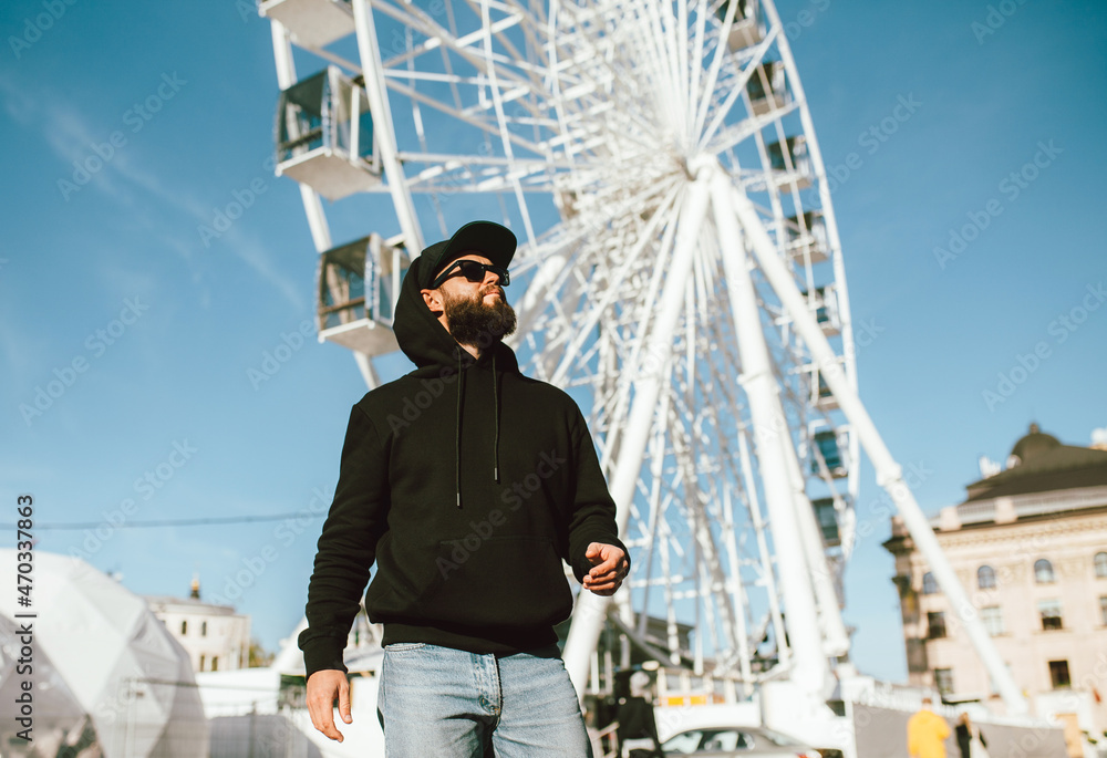 City portrait of handsome hipster guy wearing black blank hoodie with ...