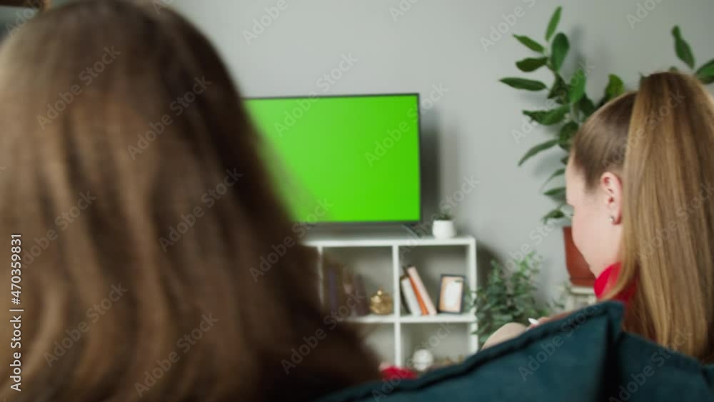 Women watching television with chroma green screen. Girlfriends ...