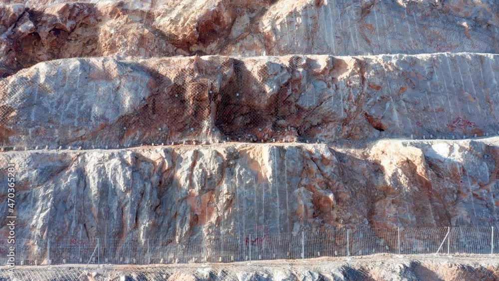 Terraces on a steep slope with protective mesh netting are safety ...