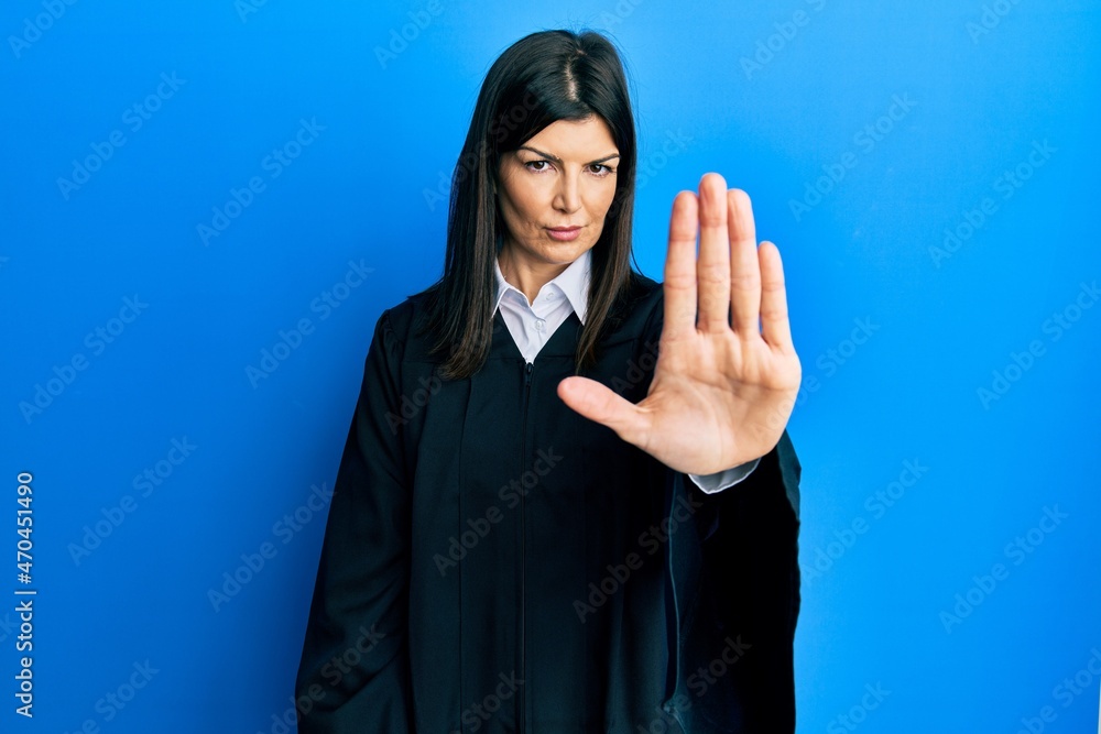 Foto de Young hispanic woman wearing judge uniform doing stop sing with ...