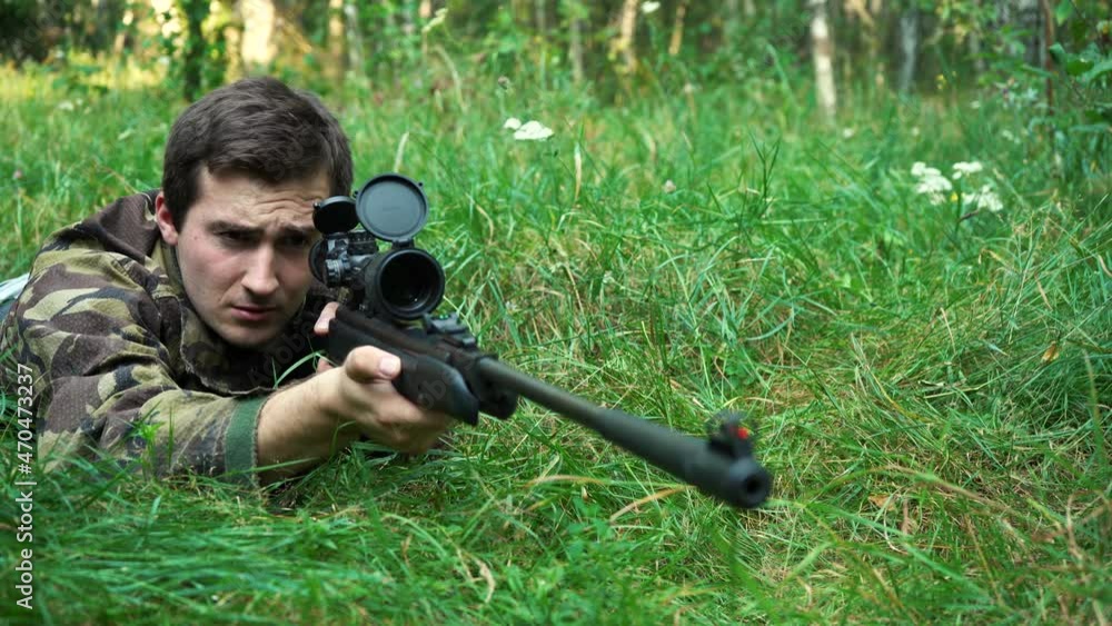 sniper aim while lying in the bushes. Stock Video | Adobe Stock