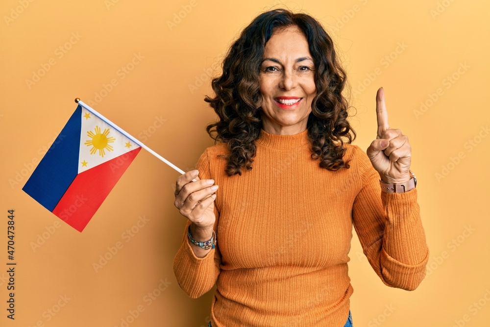 Middle age hispanic woman holding philippines flag smiling with an idea ...