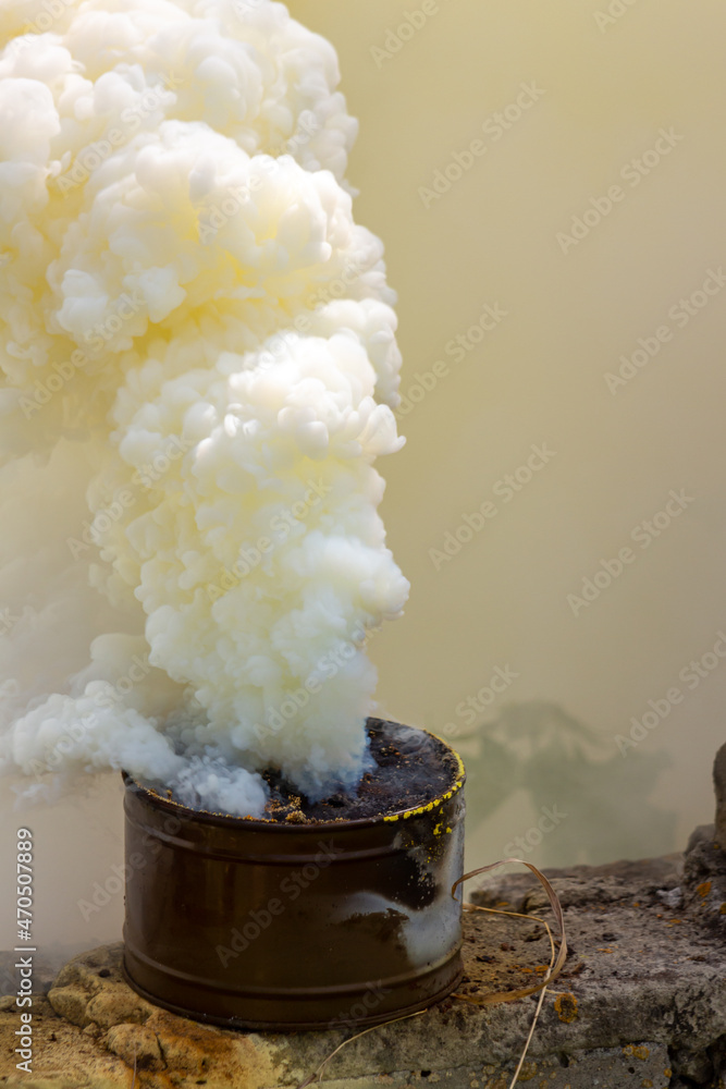 The fuming smoke grenade on a destroyed brick wall during tactical ...