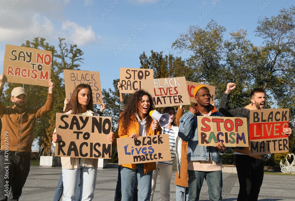 Protesters demonstrating different anti racism slogans outdoors. People ...