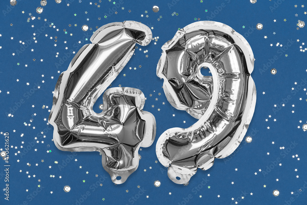 Silver foil balloon number, digit forty nine on a blue background with ...