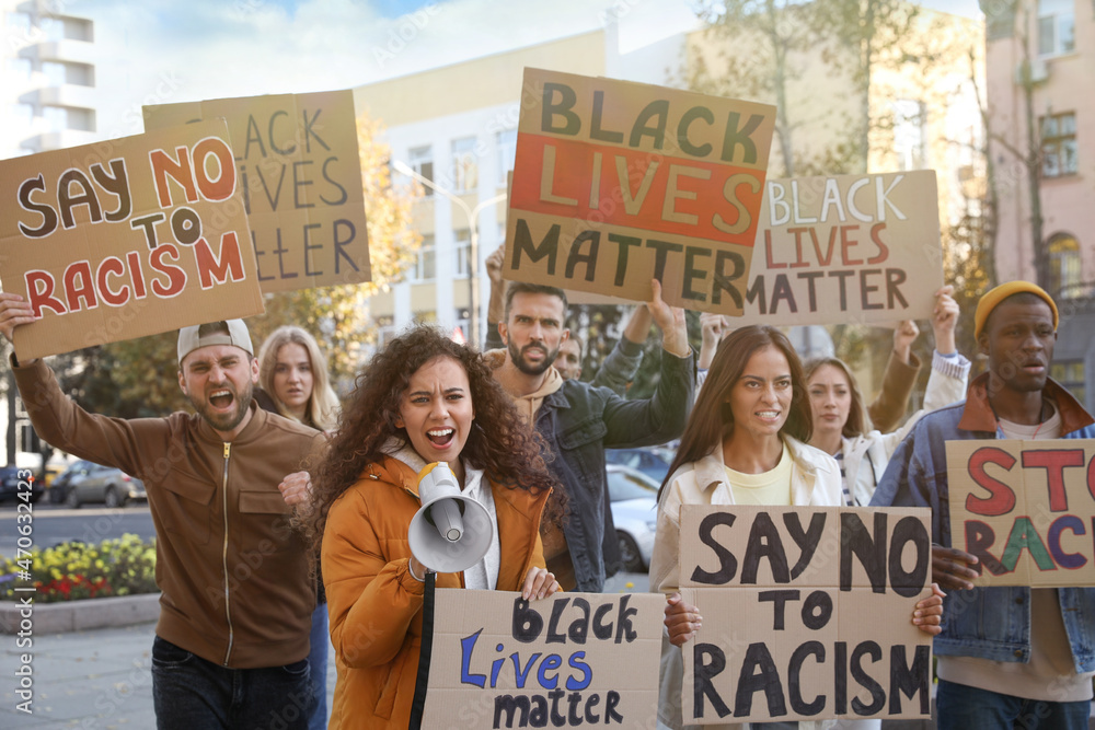 Protesters demonstrating different anti racism slogans outdoors. People ...