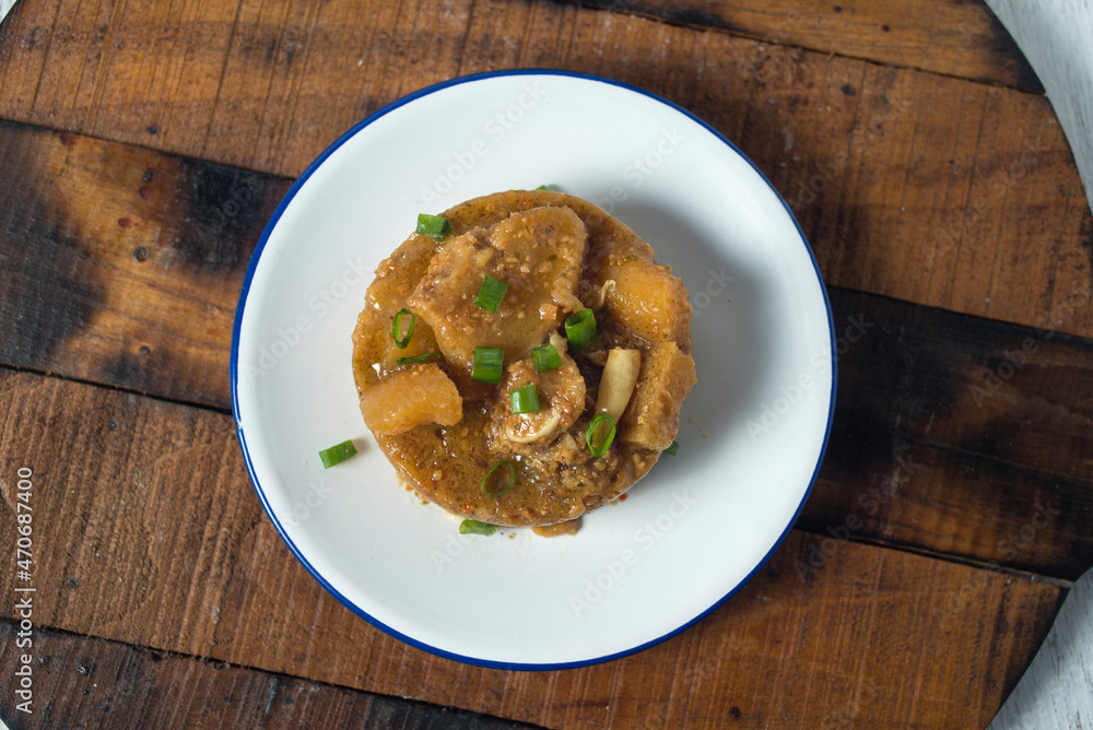 Cow skin meat cooked with spicy peanut sauce with onion leaves as ...