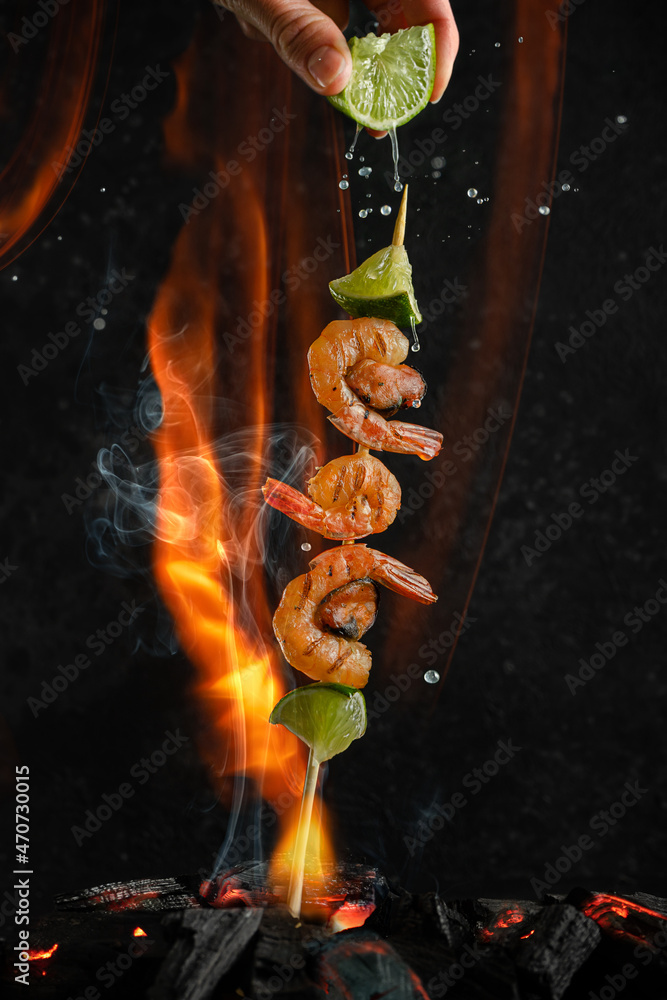 Grilled shrimp and mussel skewers over coal heat on fire and smoke ...
