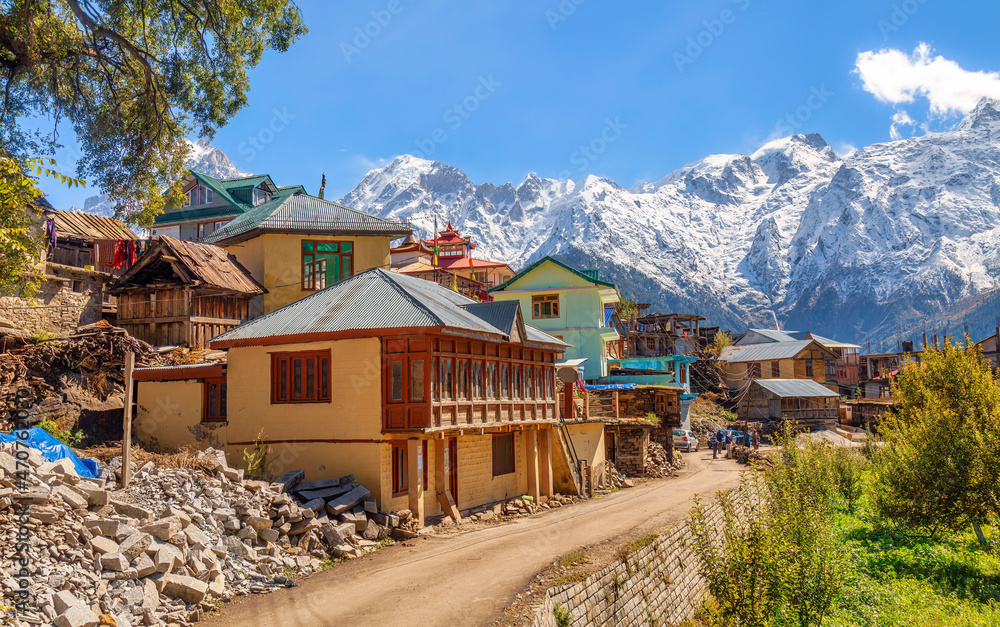 Scenic village road with residential houses and view of Kinnaur Kailash ...