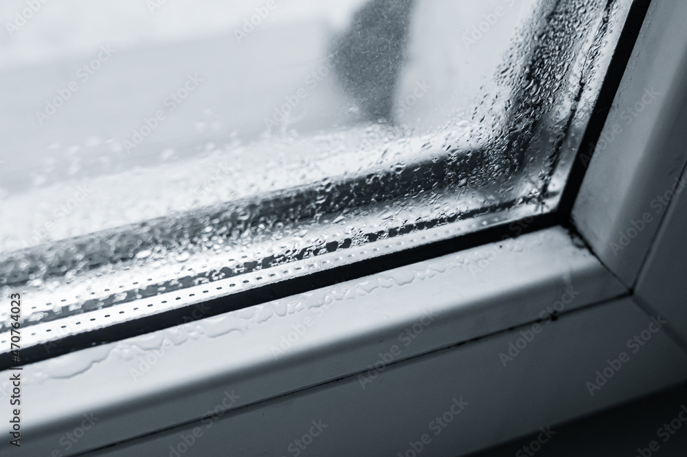 Drops of condensate on a defective plastic window. Selective focus ...