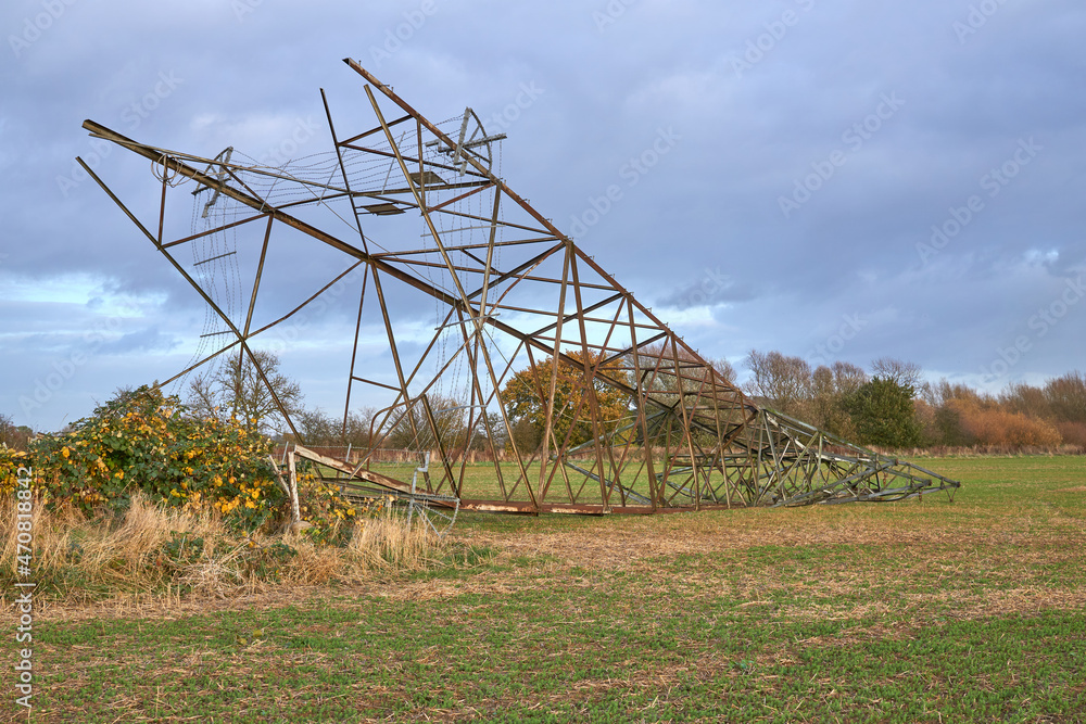 Foto de Fallen electricity pylon in a field do Stock | Adobe Stock