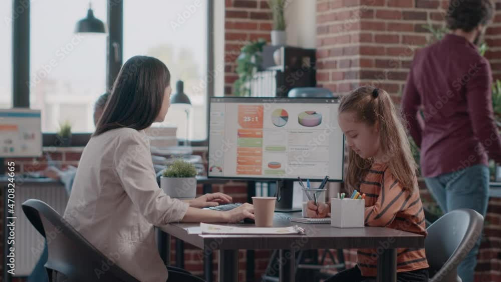Working mother planning project and little girl doodling on notebook at ...