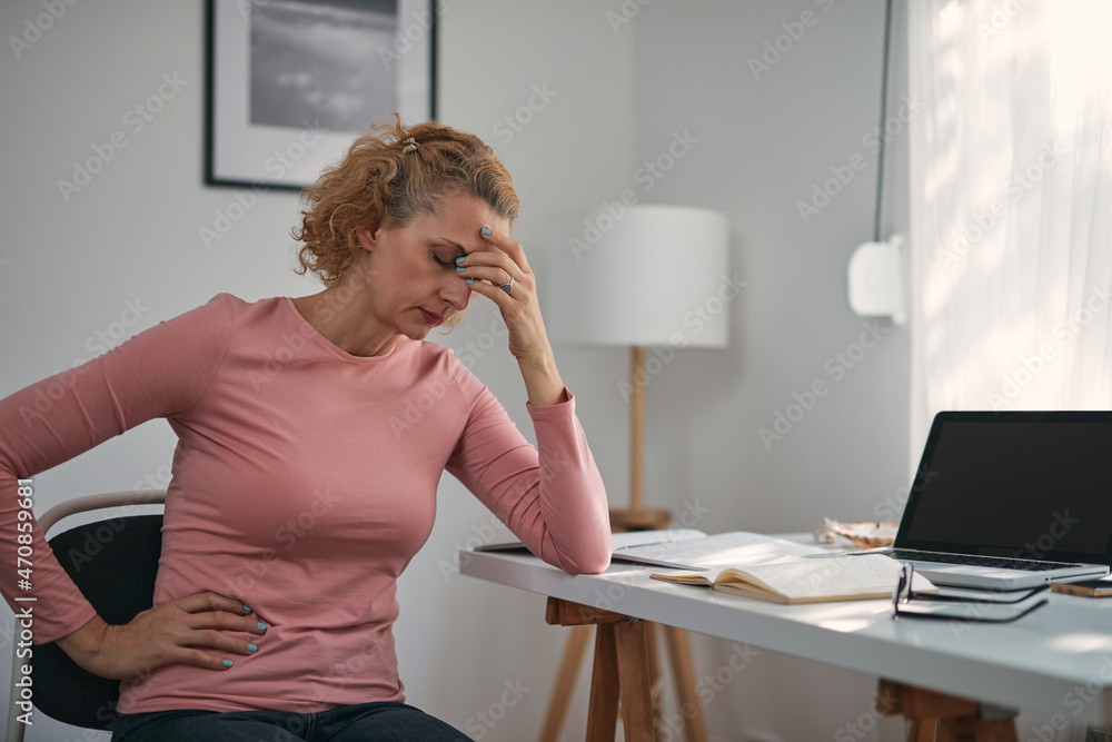 Woman with stomach, hip, spasm, cramp, headache, head pain, working ...