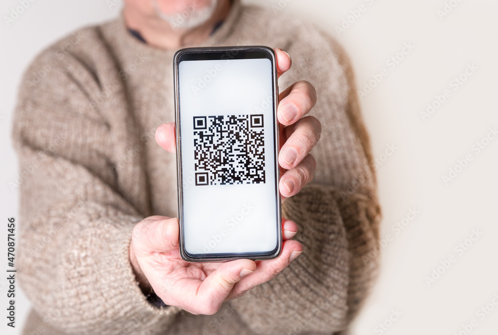 Adult man holding a smartphone with a QR-code. Virtual immunity ...