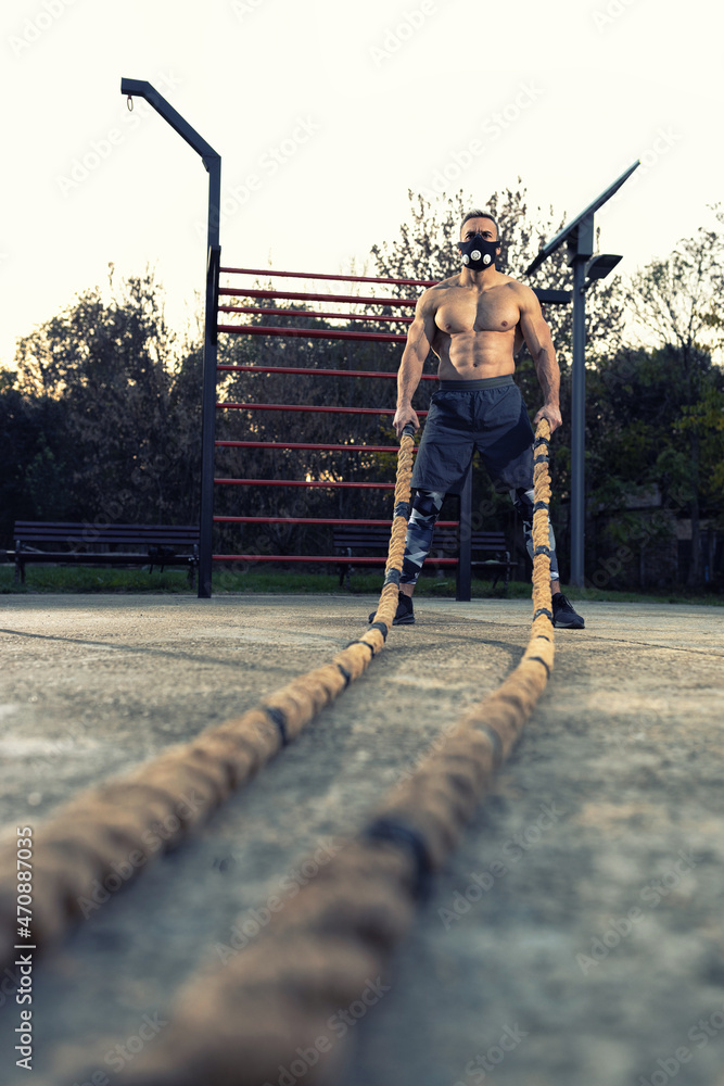 Shirtless ripped muscular man wearing running mask for respiratory ...