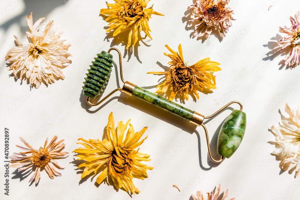Green jade massager roller for the face on a white background next to ...