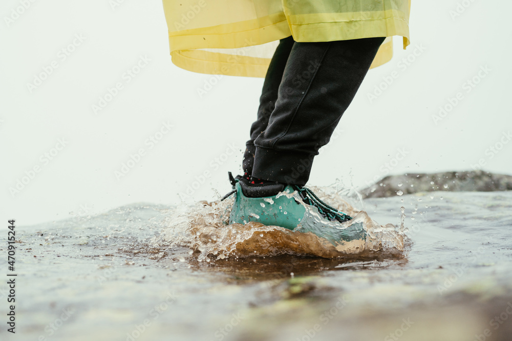 Legs in boots man tourist jumps into a puddle in the mountains with ...