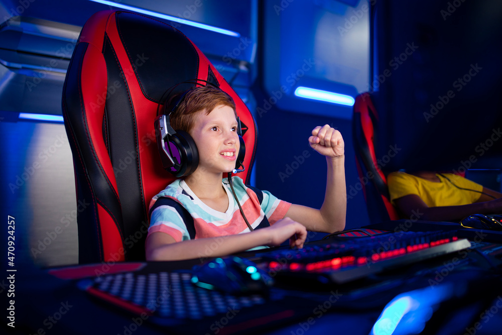 Professional young gamer boy holding fist for successfully completing ...