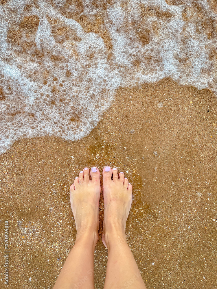 Top view of bare feet in the sand on the beach. Copy space - Foamy sea ...