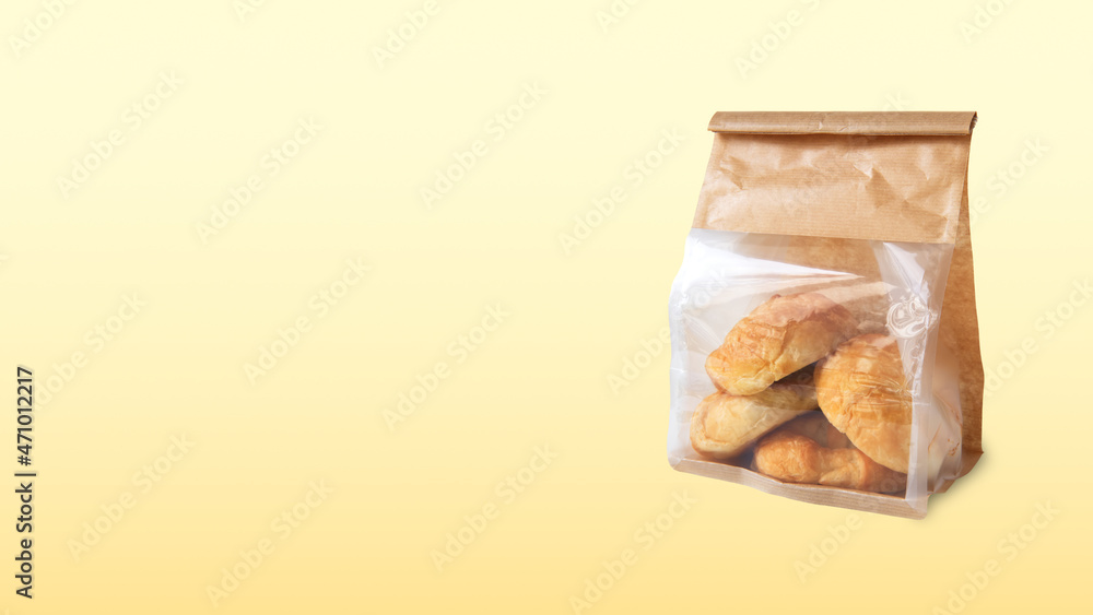 Bread, Buns or Croissants in brown paper bag isolated on light yellow ...