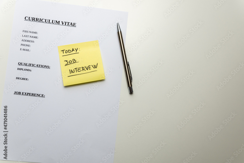 Resume form, with pen next to it, yellow ticket with "job interview ...
