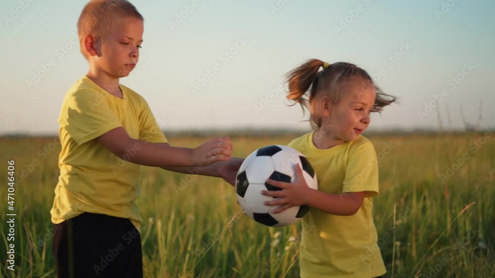 Happy children run on green grass at sunset. Family play with ball in ...
