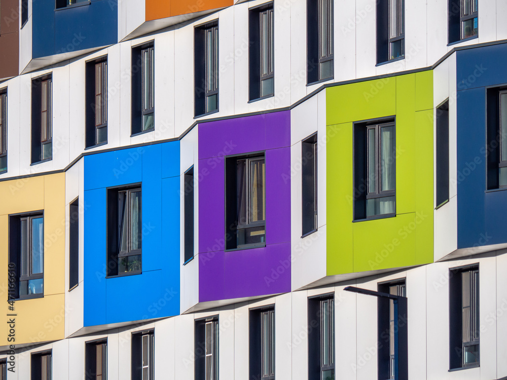 The multi-colored facade of a high-rise residential building. Rows of ...