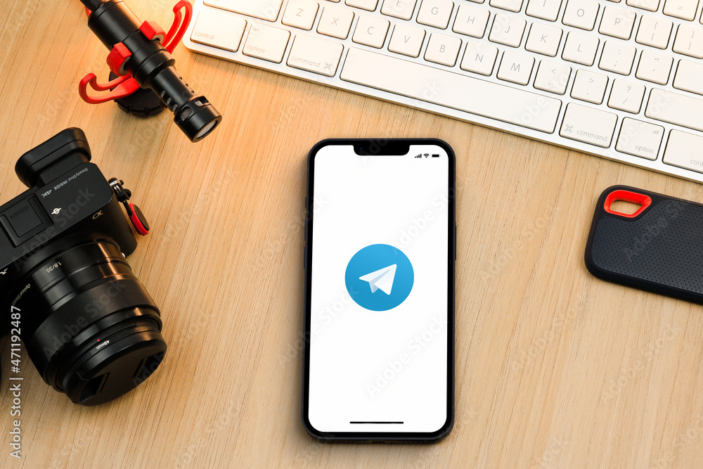 Telegram app on smartphone iPhone 13 Pro screen on wooden table ...