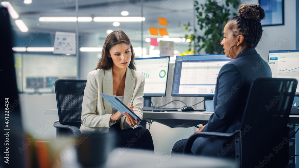 Foto de Two Female Colleagues Fondly Talk to Each Other, Smile while ...