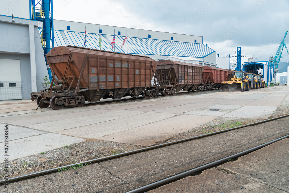 Freight trains, tractors with buckets at the terminal in the port Stock ...