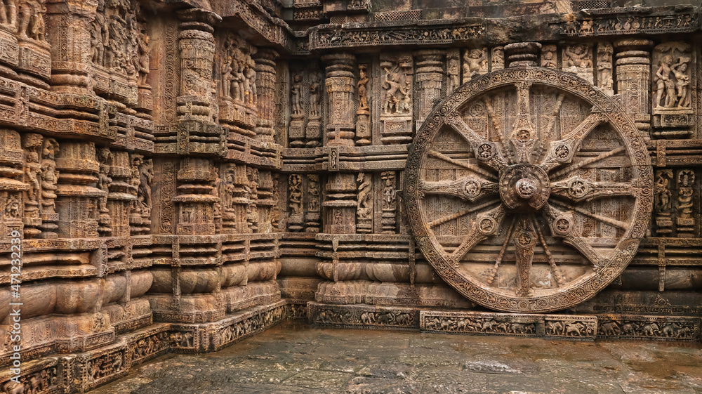 Richly carved Chariot wheel with eight spokes with a central medallion ...