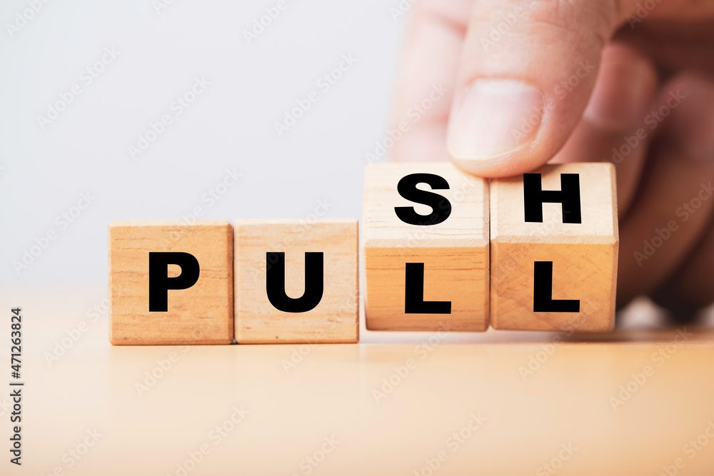 Hand flipping wooden cube block to change push and pull for business ...