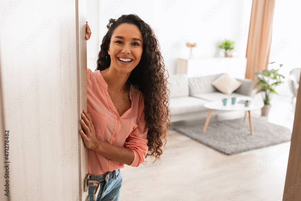 Cheerful lady inviting people to enter home Stock Photo | Adobe Stock