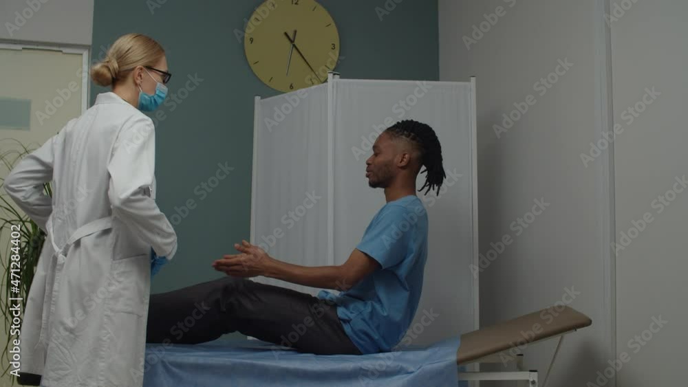 Female doctor palpating with hands sick male patient abdomen, who lying ...