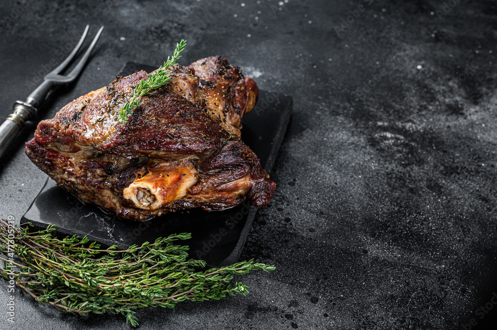 Oven Roasted lamb mutton whole leg with thyme. Black background. Top ...