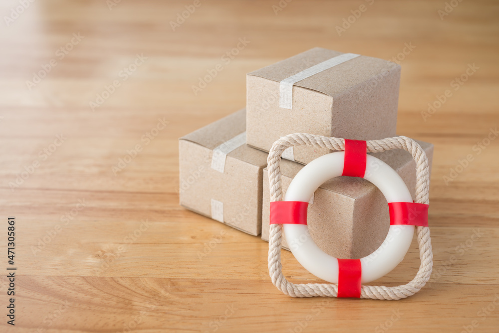 Parcel carton box on lifebuoy with wooden table background. Parcel or ...