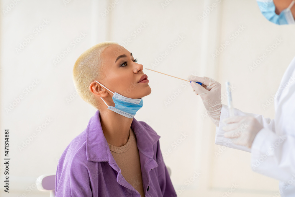 Coronavirus diagnostic. Nurse making covid-19 PCR test for lady, using ...