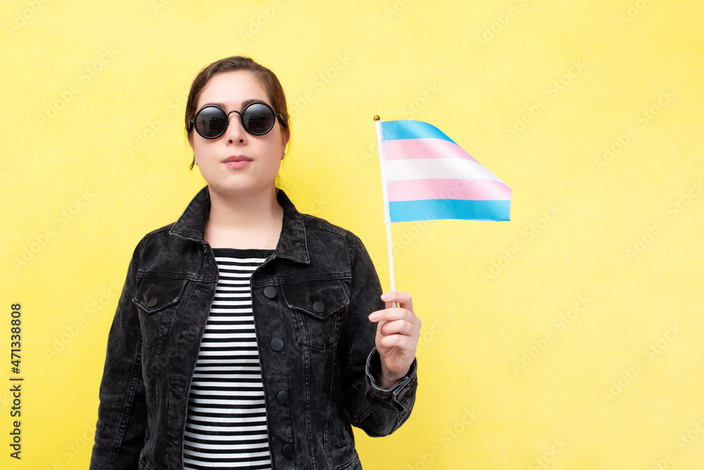 Serious young woman hold transgender pride flag. Lgbtq+, queer concept ...