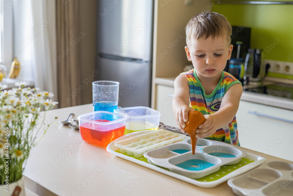 Cute baby boy learning mixing different colors with water and paint in ...