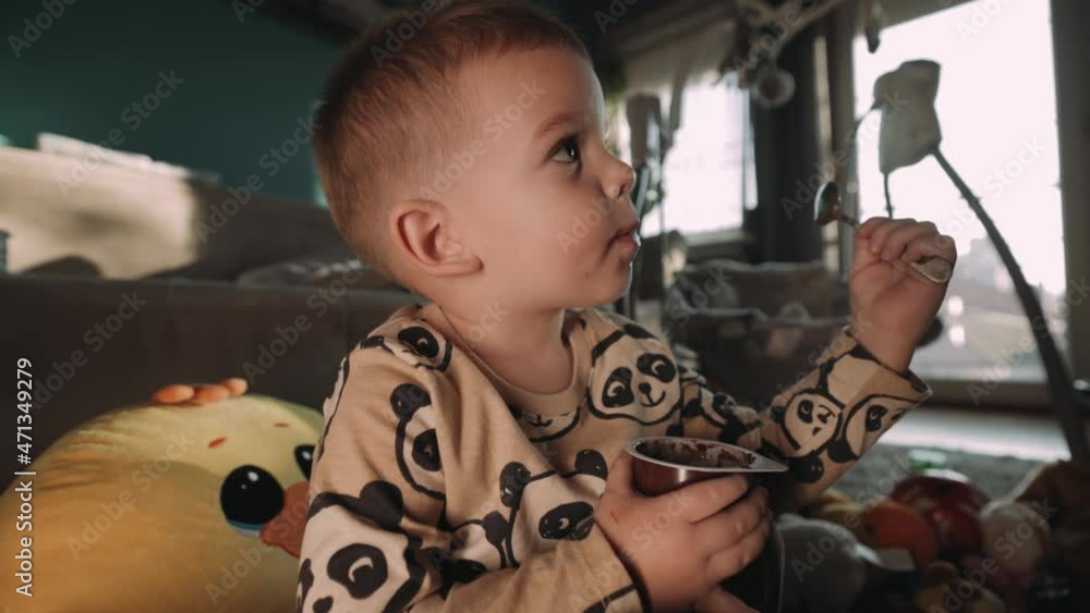 Close up of a cute little boy with a messy face eating chocolate ...