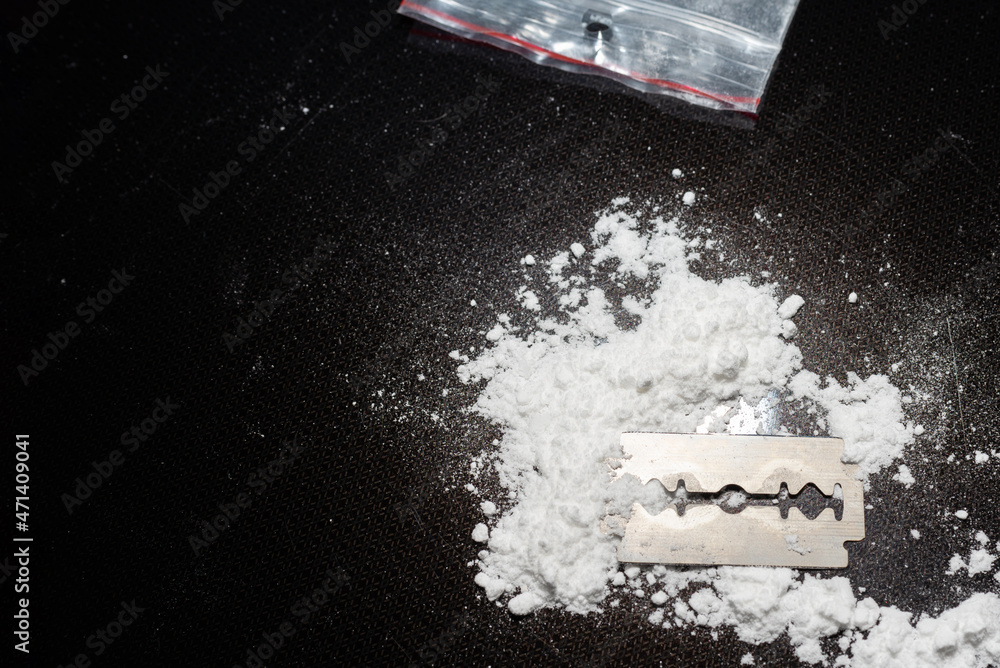 Razor Blade on drug powder,cocaine bag on reflection black background ...